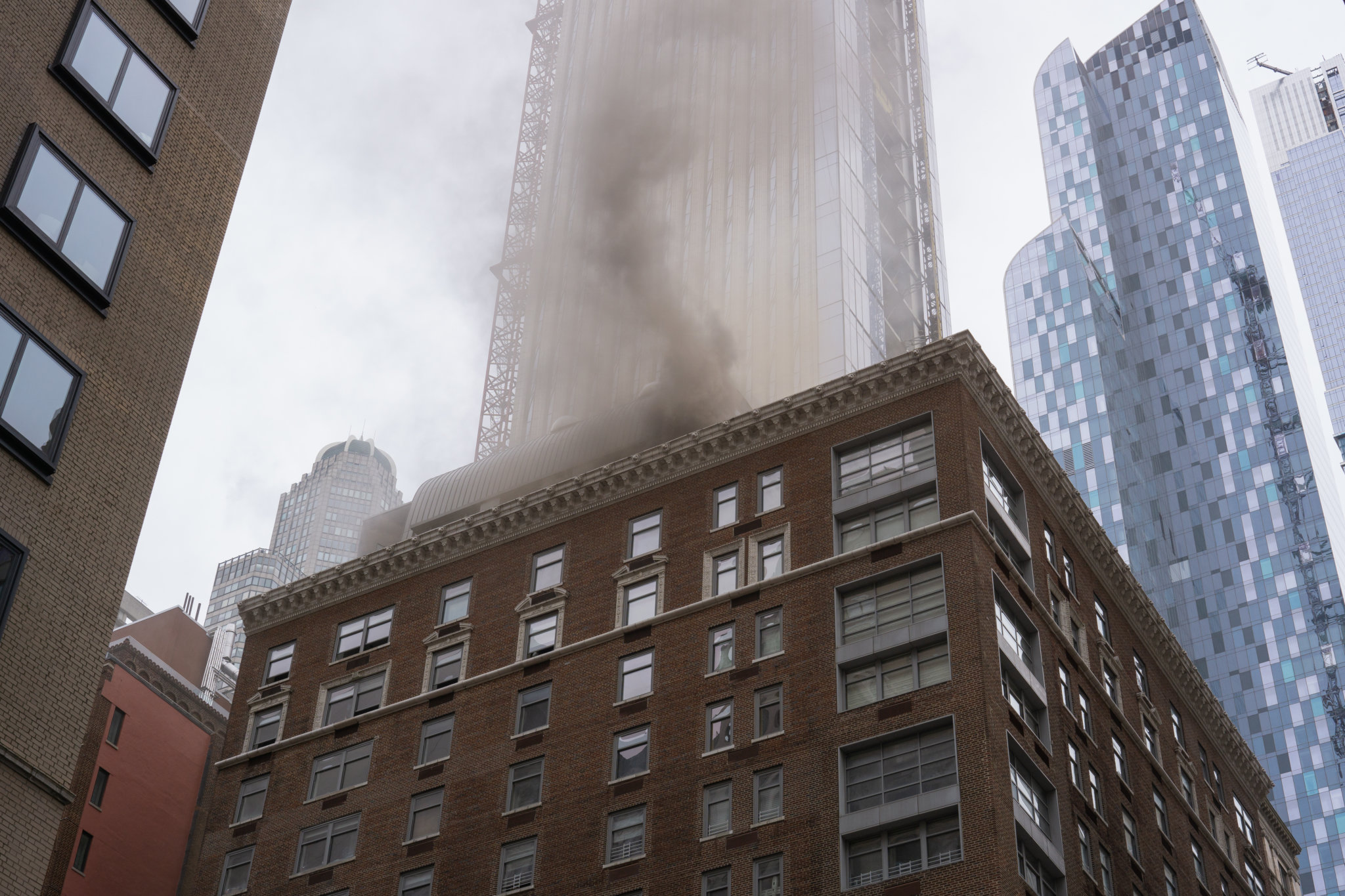Manhattan blaze rips through top of high-rise building and injures ...
